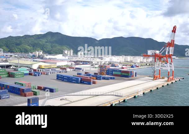 A large cargo port scene showing ships, cranes, containers, and ocean ...