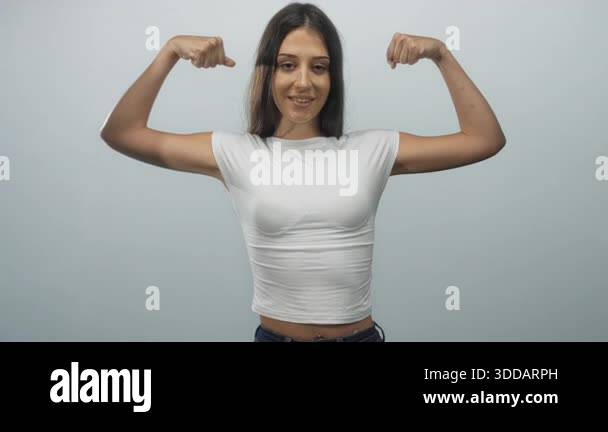 Woman flexes both arms showing biceps and midriff, smiling, wearing ...