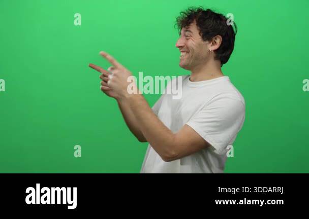 Hispanic man in white shirt smiling and pointing on a vibrant green ...