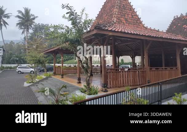 Traditional Joglo pavilion with tiered terracotta roof, carved wooden ...