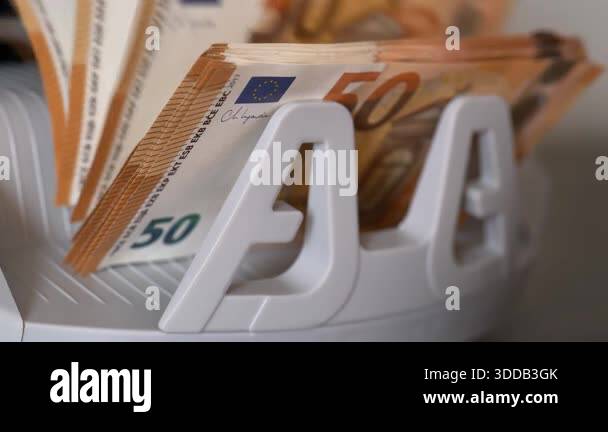 Money counter machine is counting a stack of fifty Euro banknotes at a ...