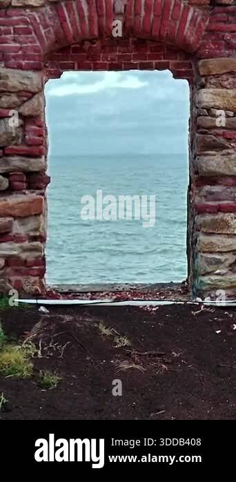 Frontal view of an ancient brick wall with a window without glass ...
