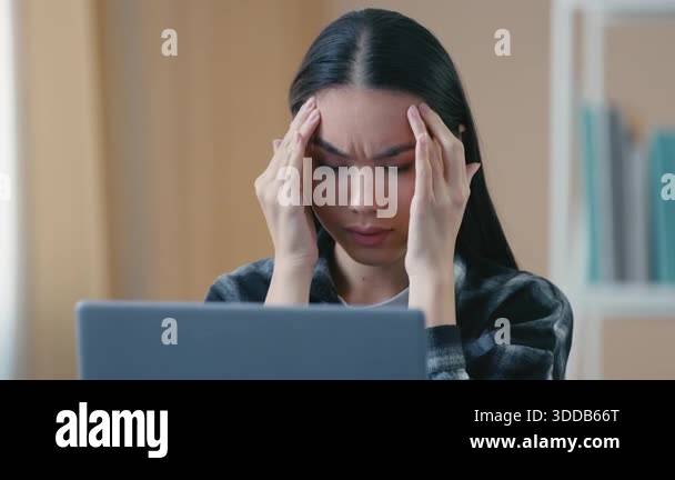 Stressed tired Asian Korean woman working laptop at home holding head ...
