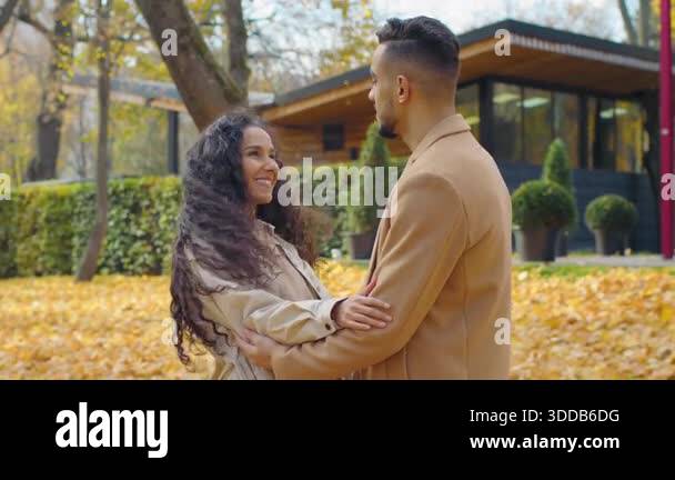 Hispanic happy couple in love outdoors talking in city fall season man ...
