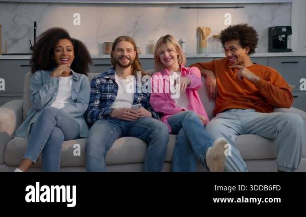 Multiracial group of friends relaxing couch at home watching TV ...