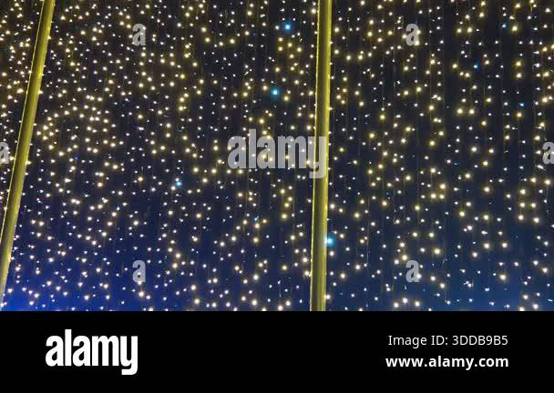 Flashing yellow and blue modern garlands of light bulbs in evening ...