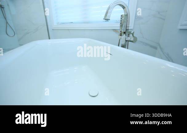 Sleek chrome faucet on white integrated bathroom sink set on a polished ...