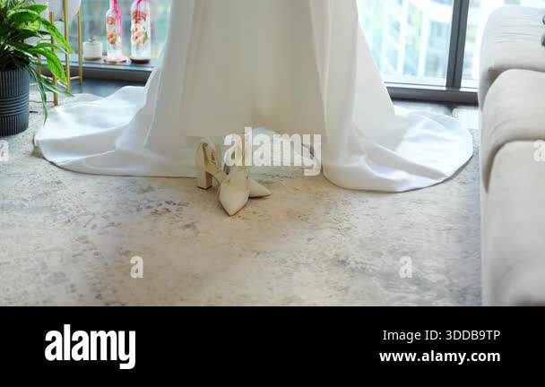 Bridal wedding dress with elegant white heels placed beneath the gown ...
