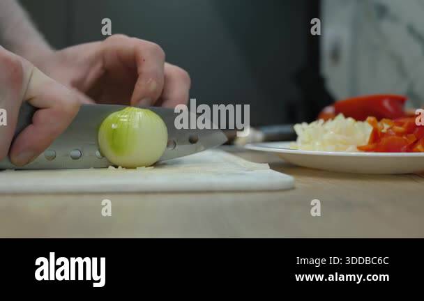 A chefs hands skillfully chop onions on a board, surrounded by colorful ...