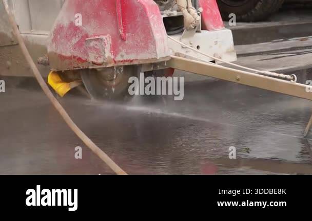 Cutting concrete with an industrial diamond floor saw. Close-up of an ...