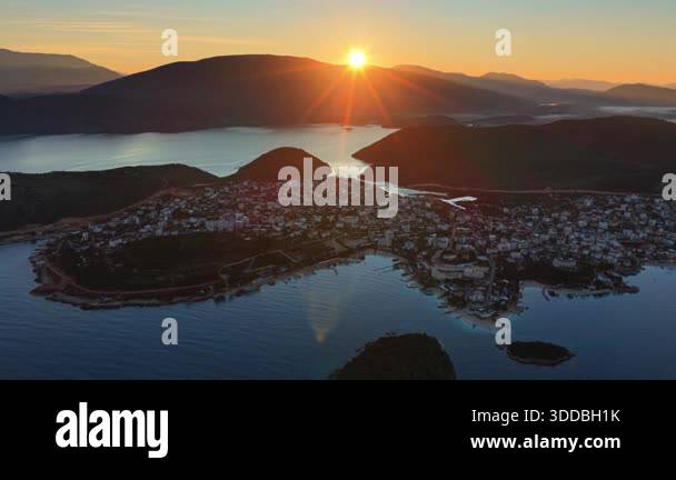 Aerial drone view of a fisherman rowing through deep turquoise waters ...