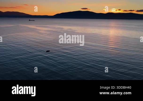 Aerial drone view of a lone fisherman rowing his small wooden boat ...