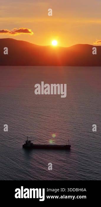 Aerial drone view of a fisherman rowing a weathered wooden boat across ...