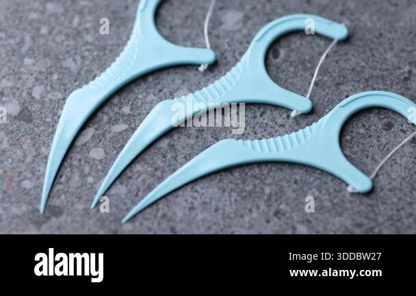 A slow panning shot showing a single dental toothpick with floss placed ...