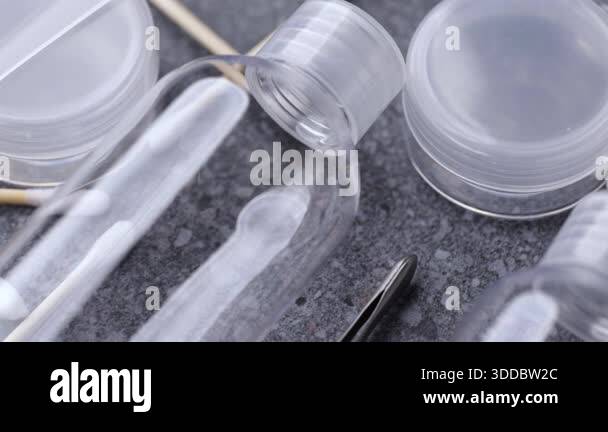 A panning view of transparent travel bottles placed with cotton swabs ...