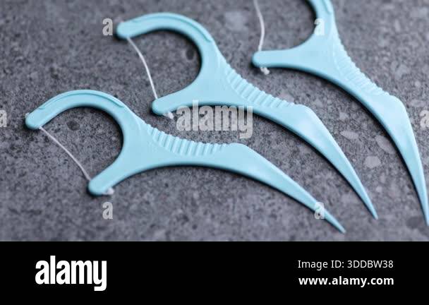 A gentle panning shot of a dental toothpick with floss resting on a ...