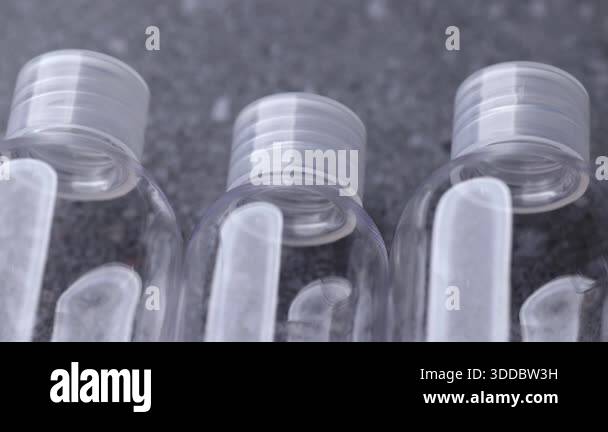 A slow camera pan across an assortment of transparent travel bottles ...