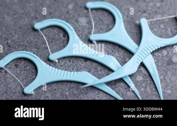 A slow panning view of dental toothpicks with floss scattered across a ...