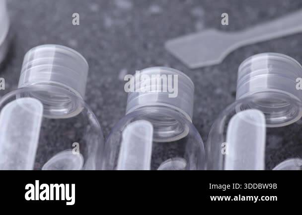 A smooth panning shot of clear cosmetic travel bottles arranged on a ...