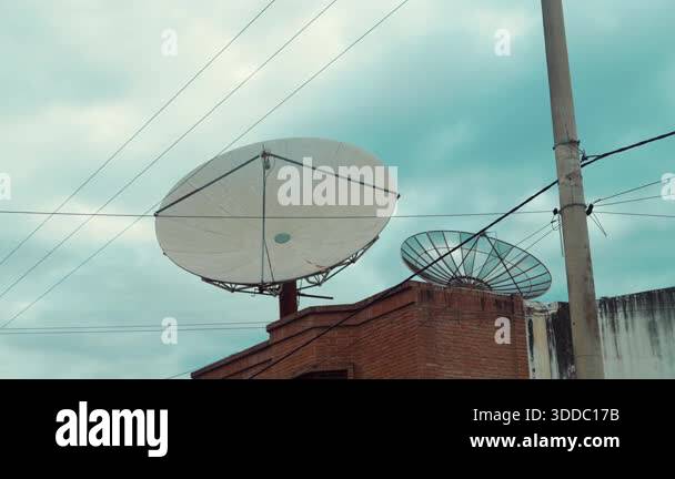 Large rooftop satellite dish with utility pole and power lines. High ...