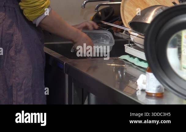 Woman washing kitchen utensils Stock Video Footage - Alamy
