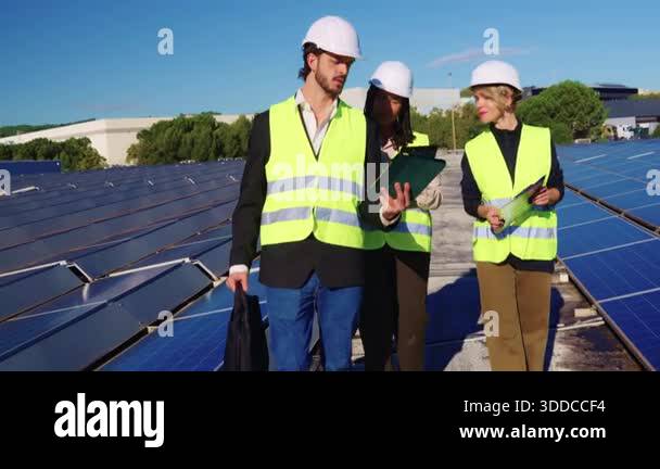 Team of multiethnic electrical engineers wearing safety gear walking on ...