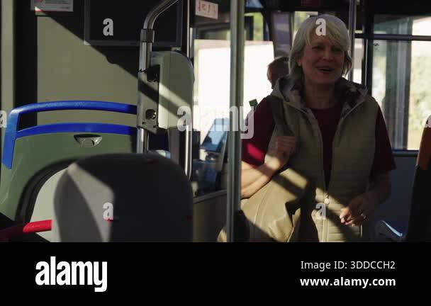 Happy senior citizens getting on a public bus. An elderly man with a ...