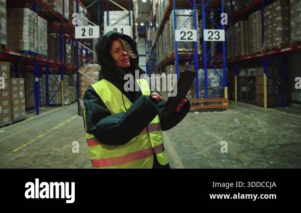 Professional female worker in a cold storage warehouse using a digital ...