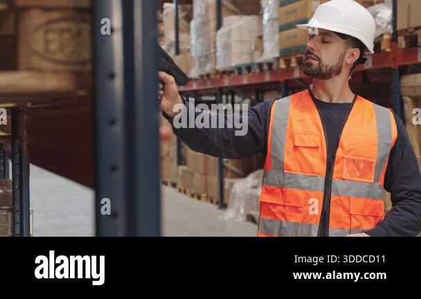 Male worker in a hard hat and safety vest scanning barcodes on ...