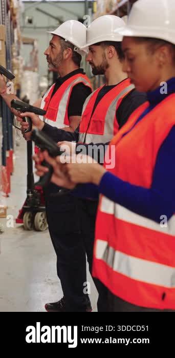 Diverse group of warehouse employees using barcode scanners for ...