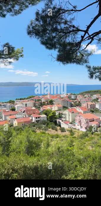 Panoramic vertical shot of a sunny seaside resort town with a church ...