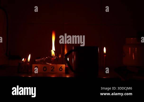 Cubes with the number 2026, burning candles and an incandescent light ...