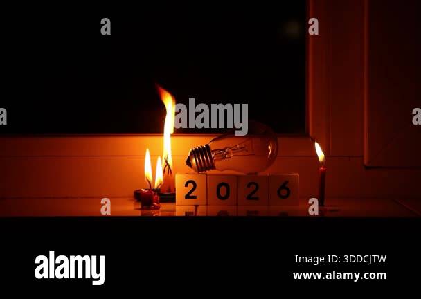 Cubes with the numbers 2026, burning candles, and an incandescent light ...