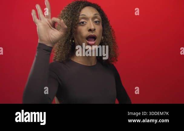 Transgender woman of hispanic descent holds up her hand making ok sign ...