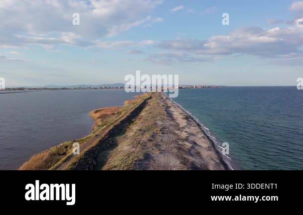 Birds eye view of narrow empty quiet beach with dry sand right and ...