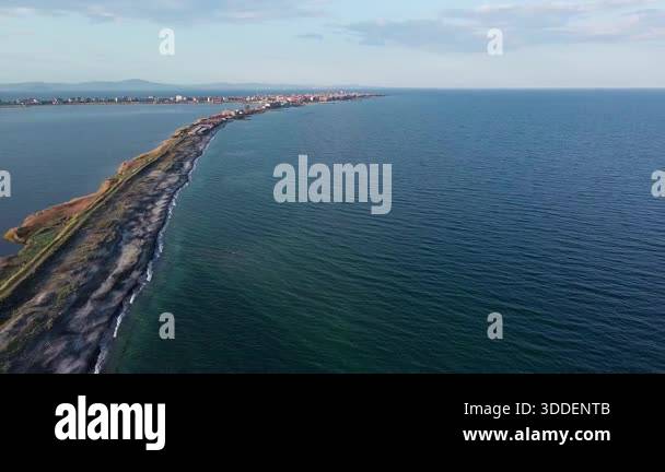 Birds eye view of narrow empty quiet beach with dry sand right and ...