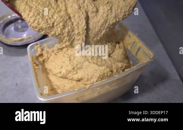 Stockholm, Sweden Homemade pureed hummus is poured into a plastic ...
