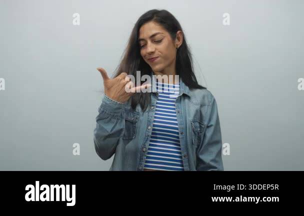 Woman showing call me hand gesture, pointing with thumb and pinky while ...