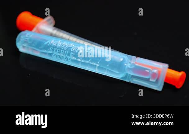 Sterile water and needle used for dissolving drugs from powder ...