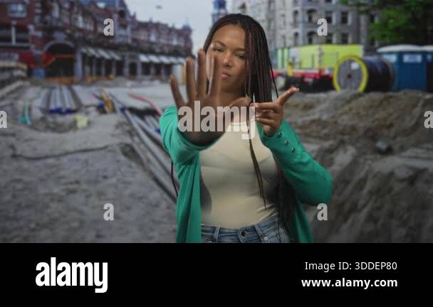 Young african american woman with hand raised palm forward toward ...