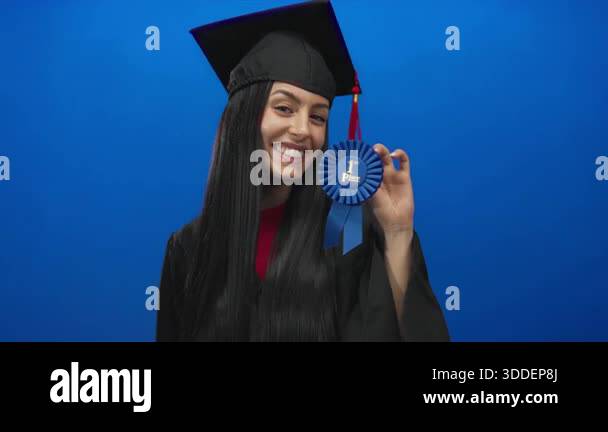 Young woman in graduation cap and gown smiles holding first-place ...