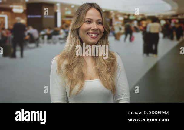 Woman smiles with open mouth and bright eyes in airport terminal ...