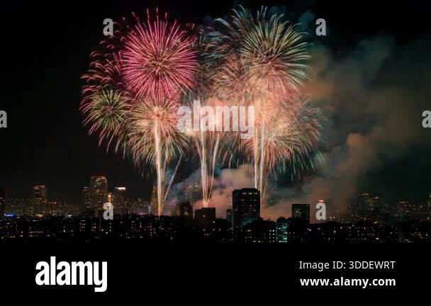 Vibrant multicolor fireworks or pyrotechnics exploding over a city ...