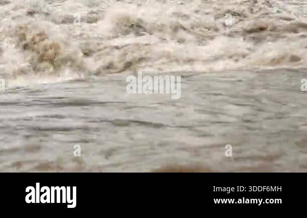 Dirty flood water flowing rapidly in river, closeup abstract detail ...