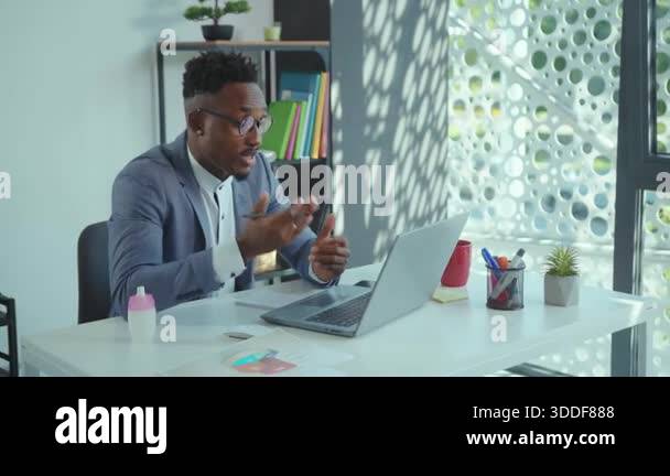 NEW YORK - April 5, 2020: African American man office worker sitting at ...