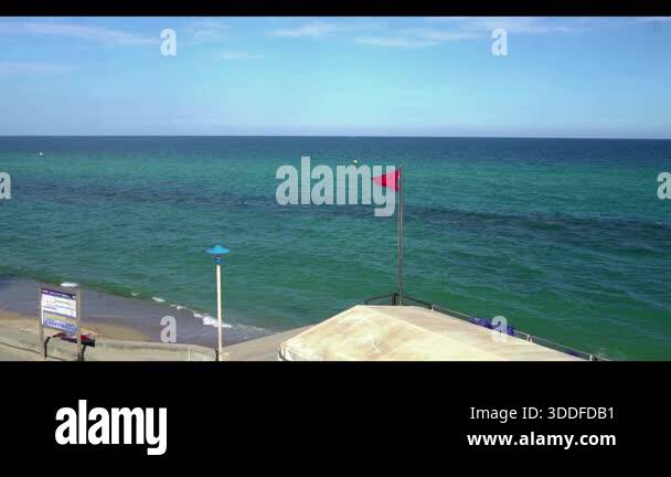 Red flag on the beach. Red flags wave in the wind on a windy but sunny ...