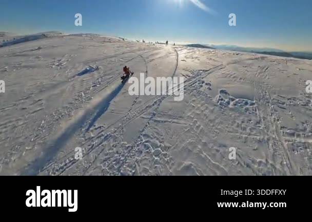 In winter mountains, guys on snowmobiles jump and ride in the winter at ...