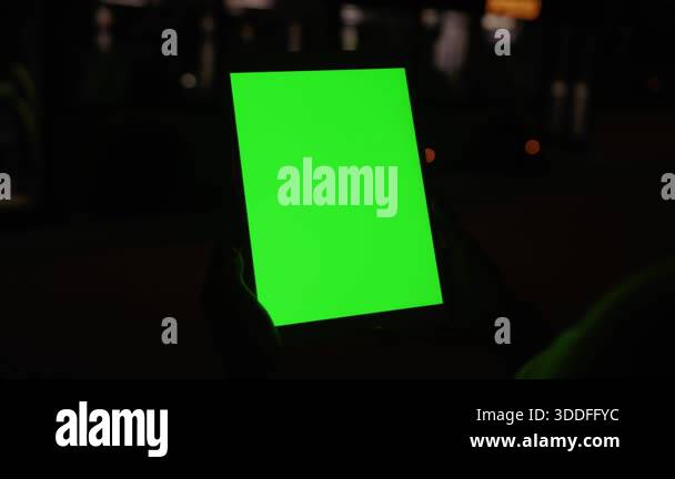Young person holding modern tablet in vertical position using chroma ...