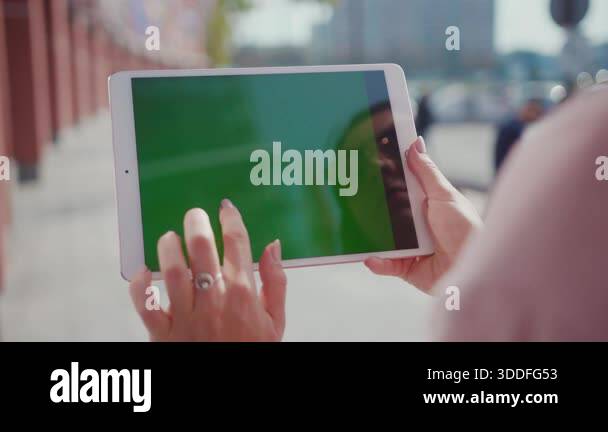 Sociable girl using modern tablet business application on mock-up green ...