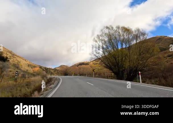 A tranquil drive through Wanaka's winding roads, showcasing lush hills ...